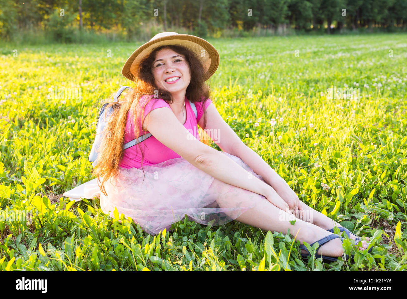 Beautiful young laughing naughty woman sitting outdoors and smiling Stock Photo - Alamy