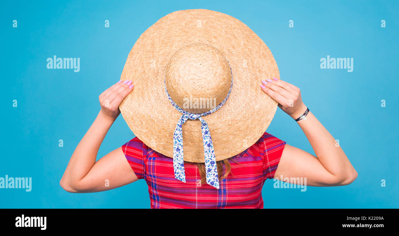 Girl is back with a hat on a blue background Stock Photo - Alamy