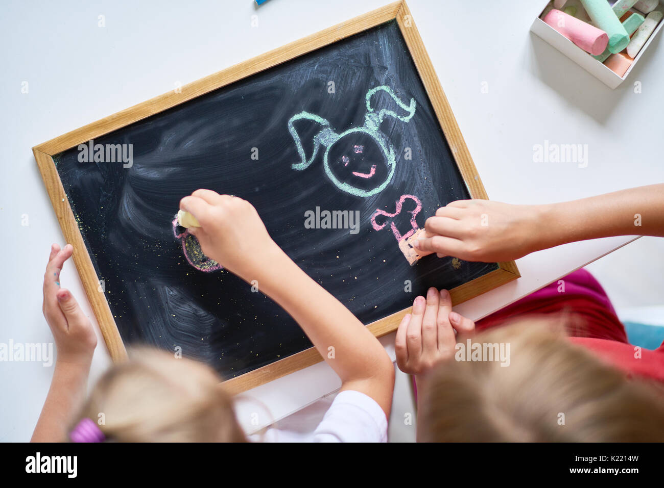 Little Girls Drawing on Chalkboard Stock Photo - Alamy