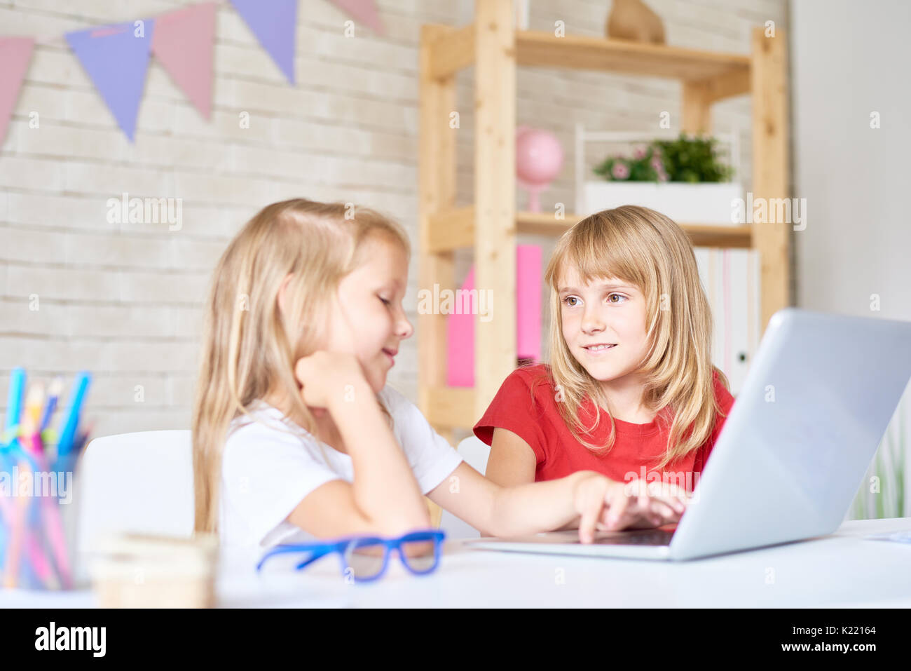 Cute Sisters Playing with Computer Stock Photo - Alamy