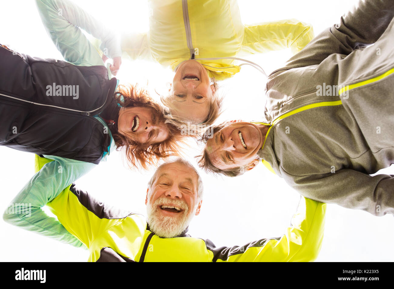 Group of senior runners outdoors, resting, arms around shoulders Stock ...