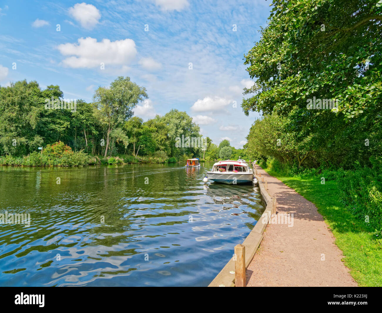 A large cabin cruiser on the River Bure, near Wroxham, while a second ...