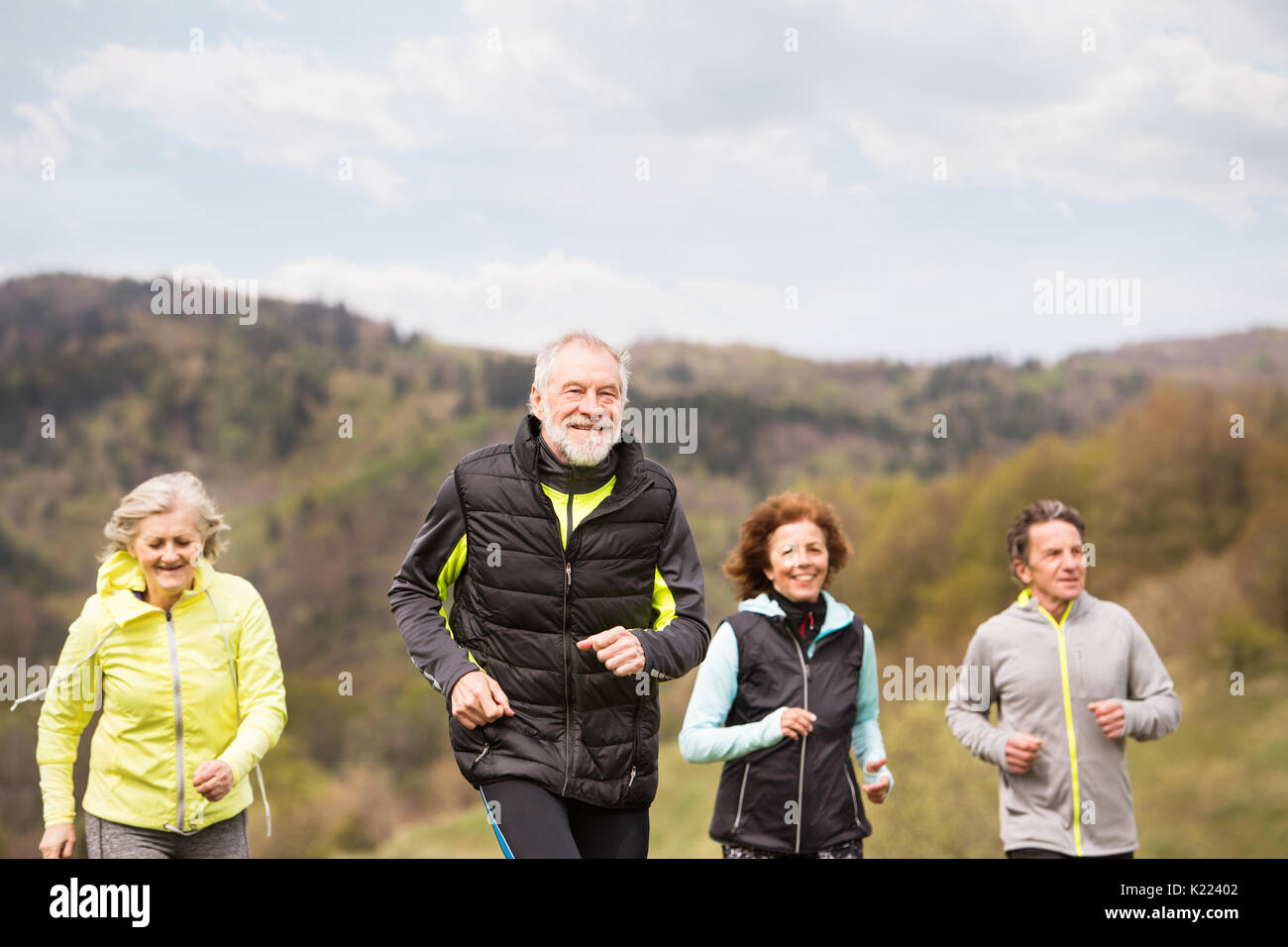 Group of seniors running outside on green hills Stock Photo - Alamy