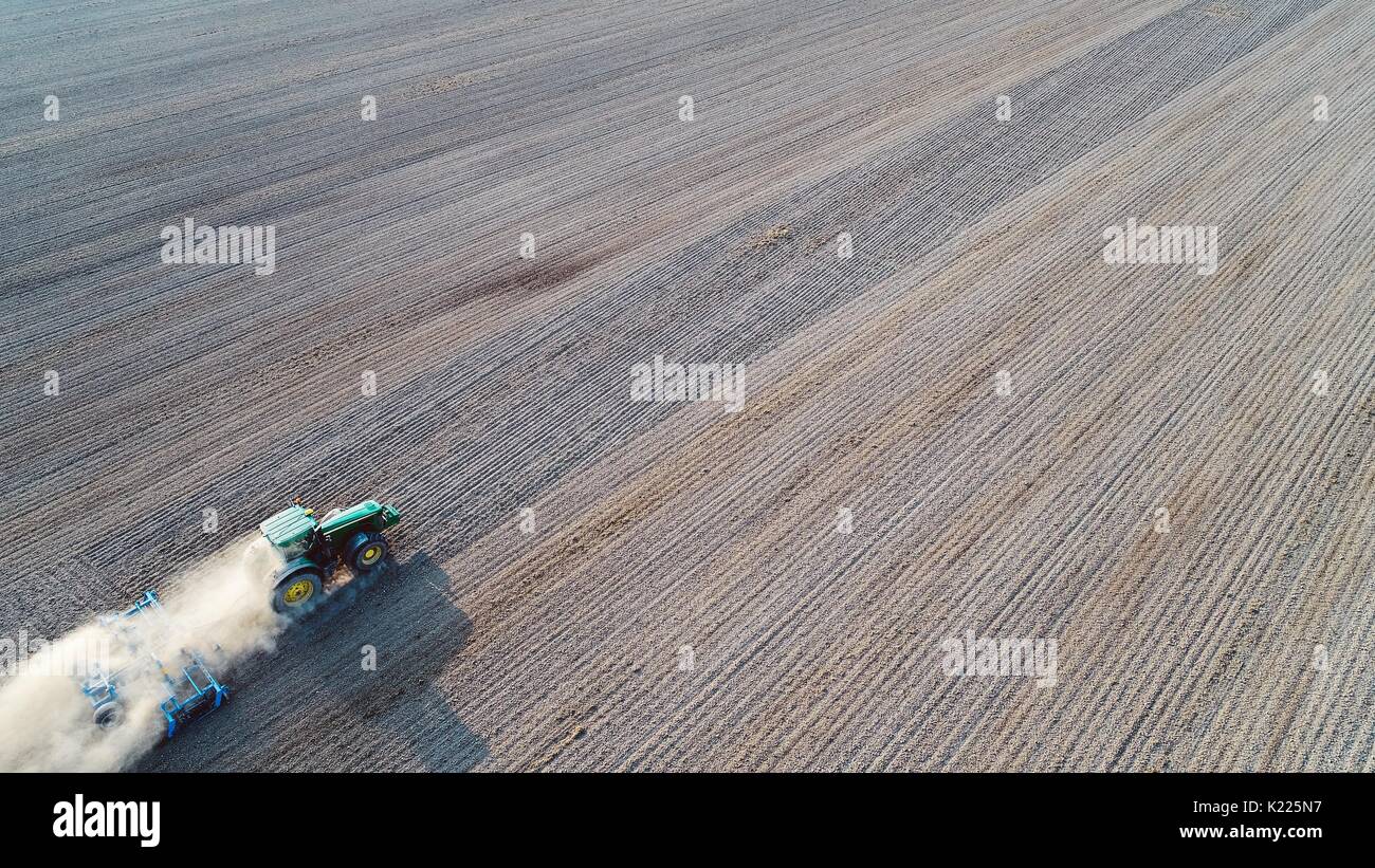 Aerial view on tractor ploughing field. Summer farm works Stock Photo ...