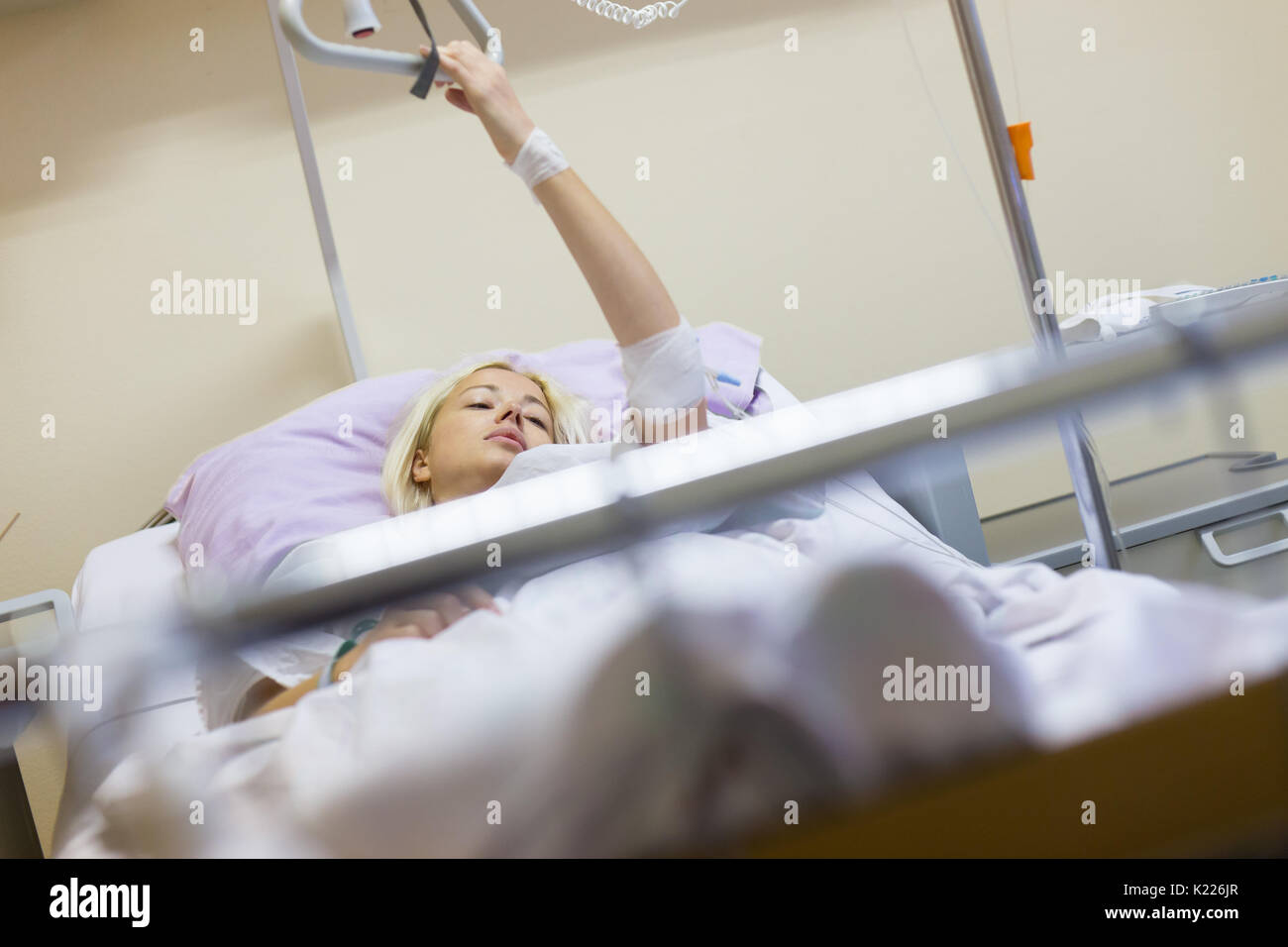 Bedridden female patient recovering after surgery in hospital care ...
