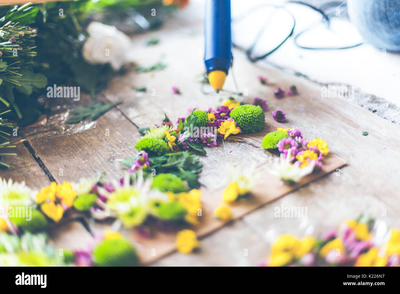 Florist making flower decoration with letters and glue. Indoors natural ...