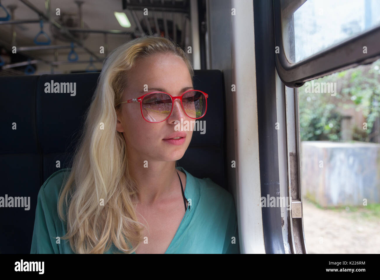 Blonde caucasian woman riding a train, looking trough window Stock ...