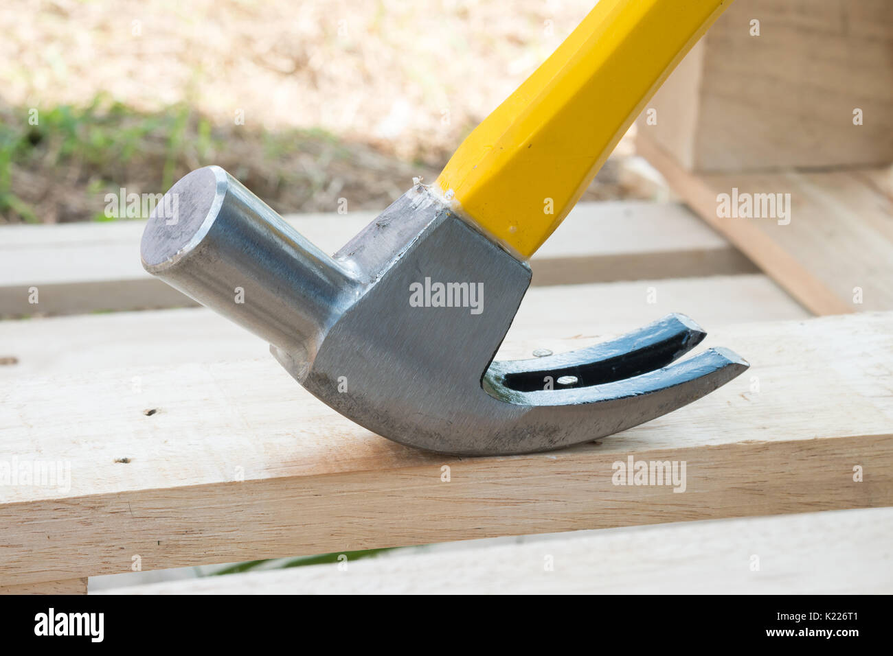 Yellow hammer and Nail Using hammer and nail on wood Stock Photo - Alamy
