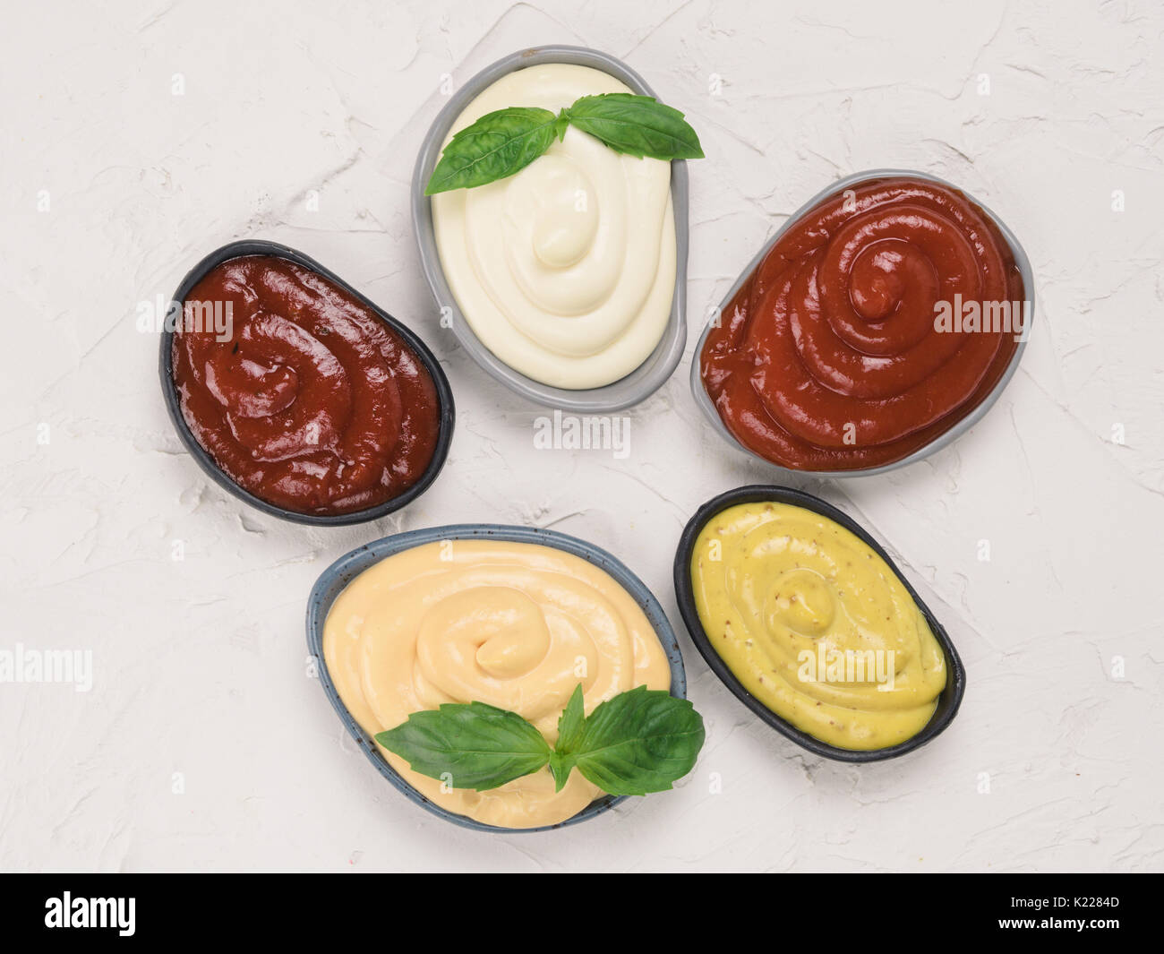 Top view of classic sauces set in trendy plates on white concrete ...