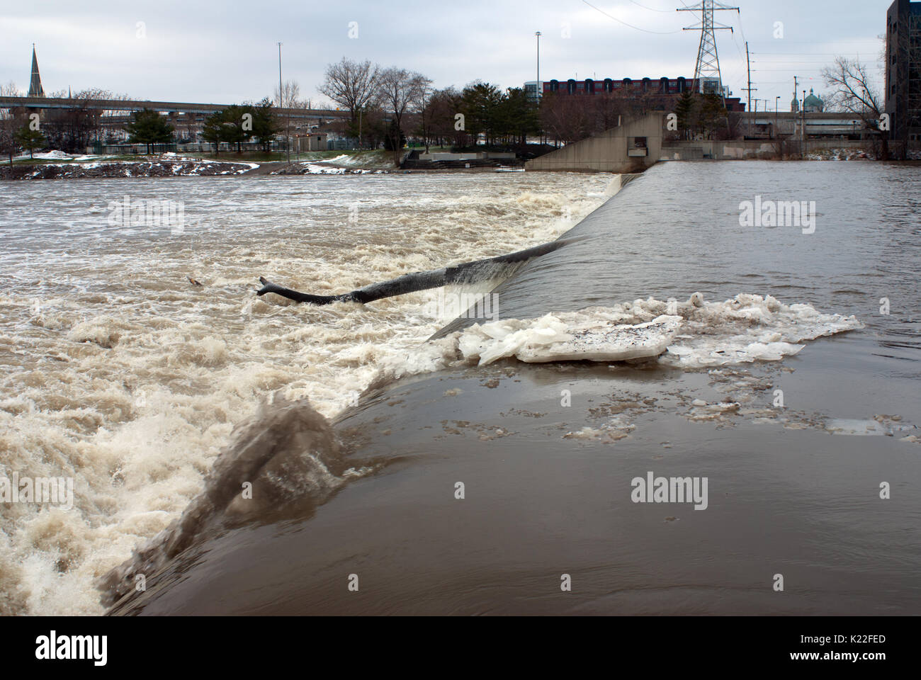 High water going over a dam in the Grand River during a winter storm ...
