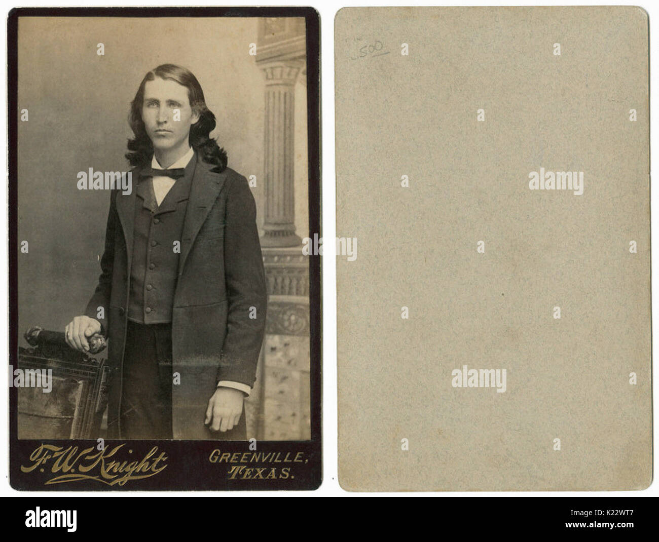 Young man standing with hand on chair Stock Photo - Alamy