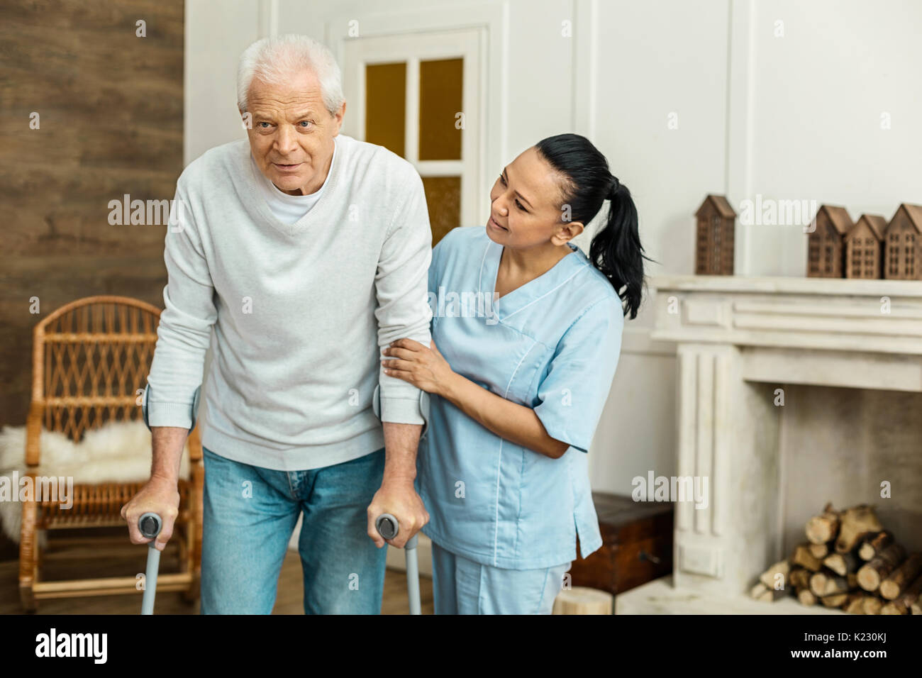 Cheerful friendly caregiver doing her job Stock Photo - Alamy