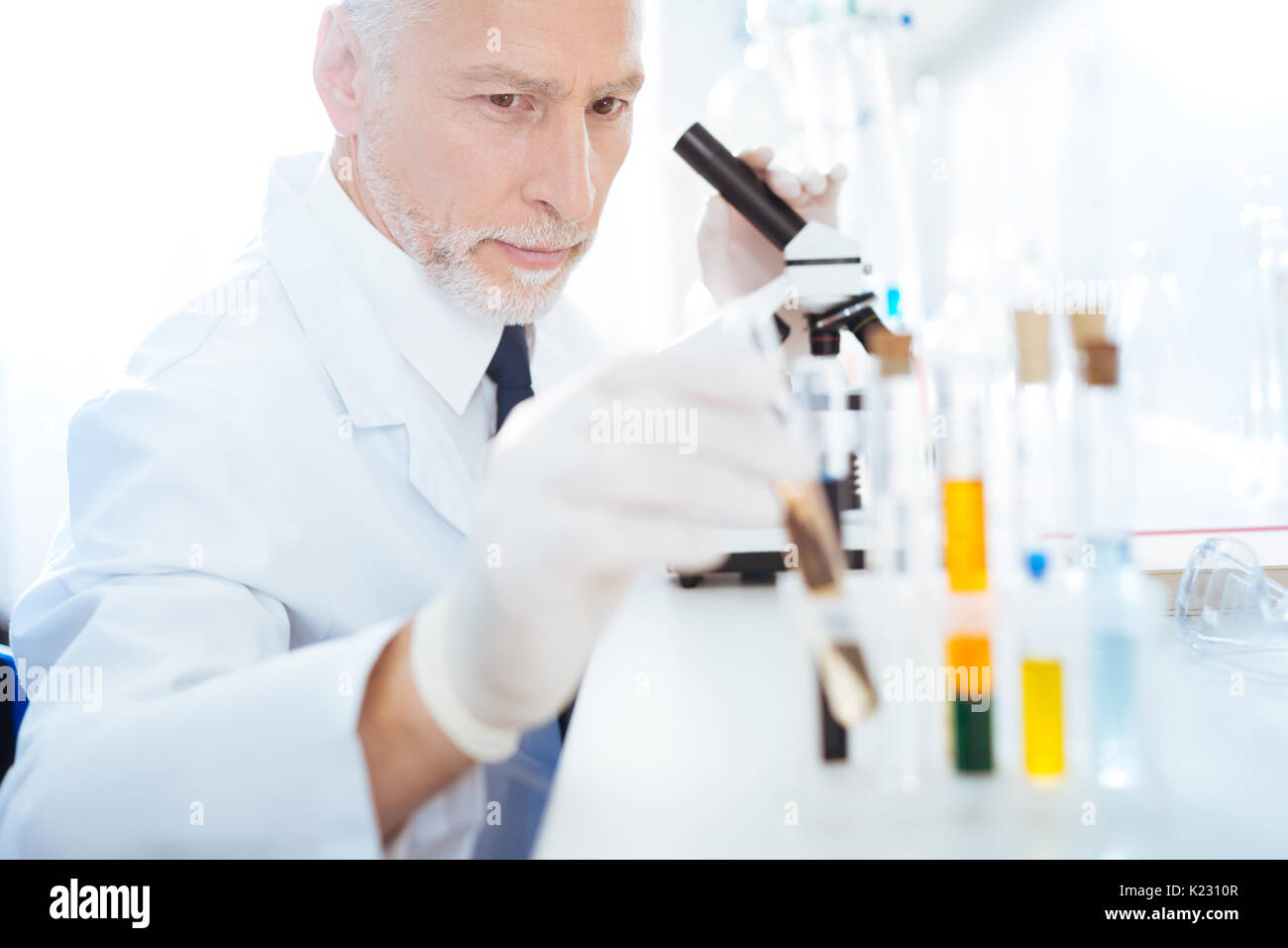 Positive delighted mature scientist doing experiment Stock Photo - Alamy