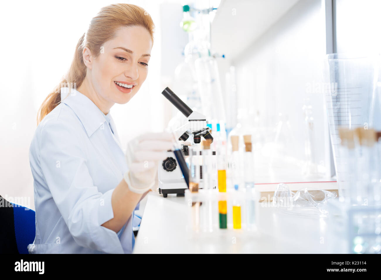 Positive delighted female taking test tube Stock Photo - Alamy