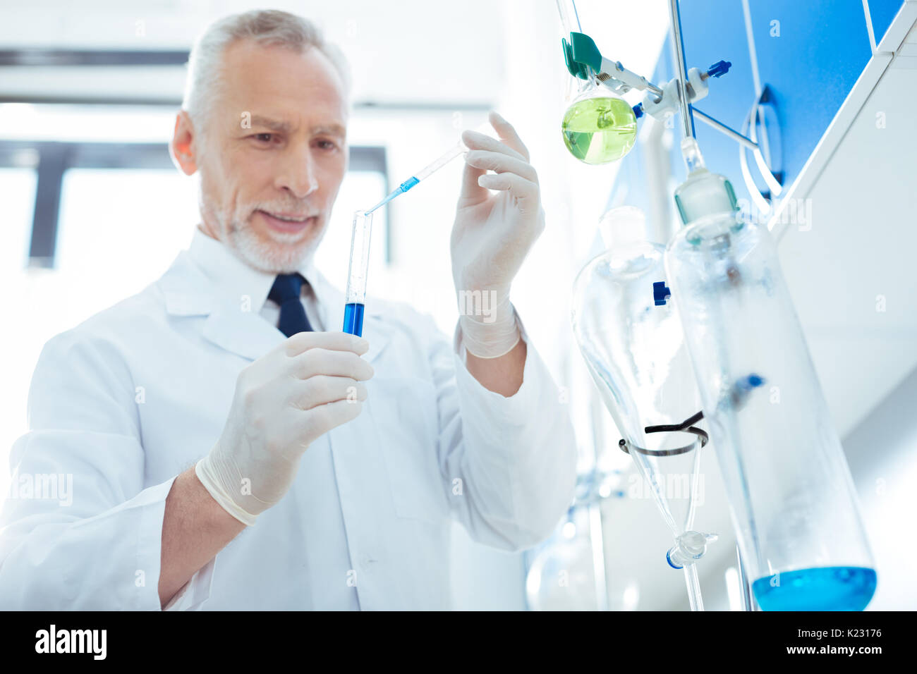 Positive delighted scientist mixing reagents Stock Photo - Alamy