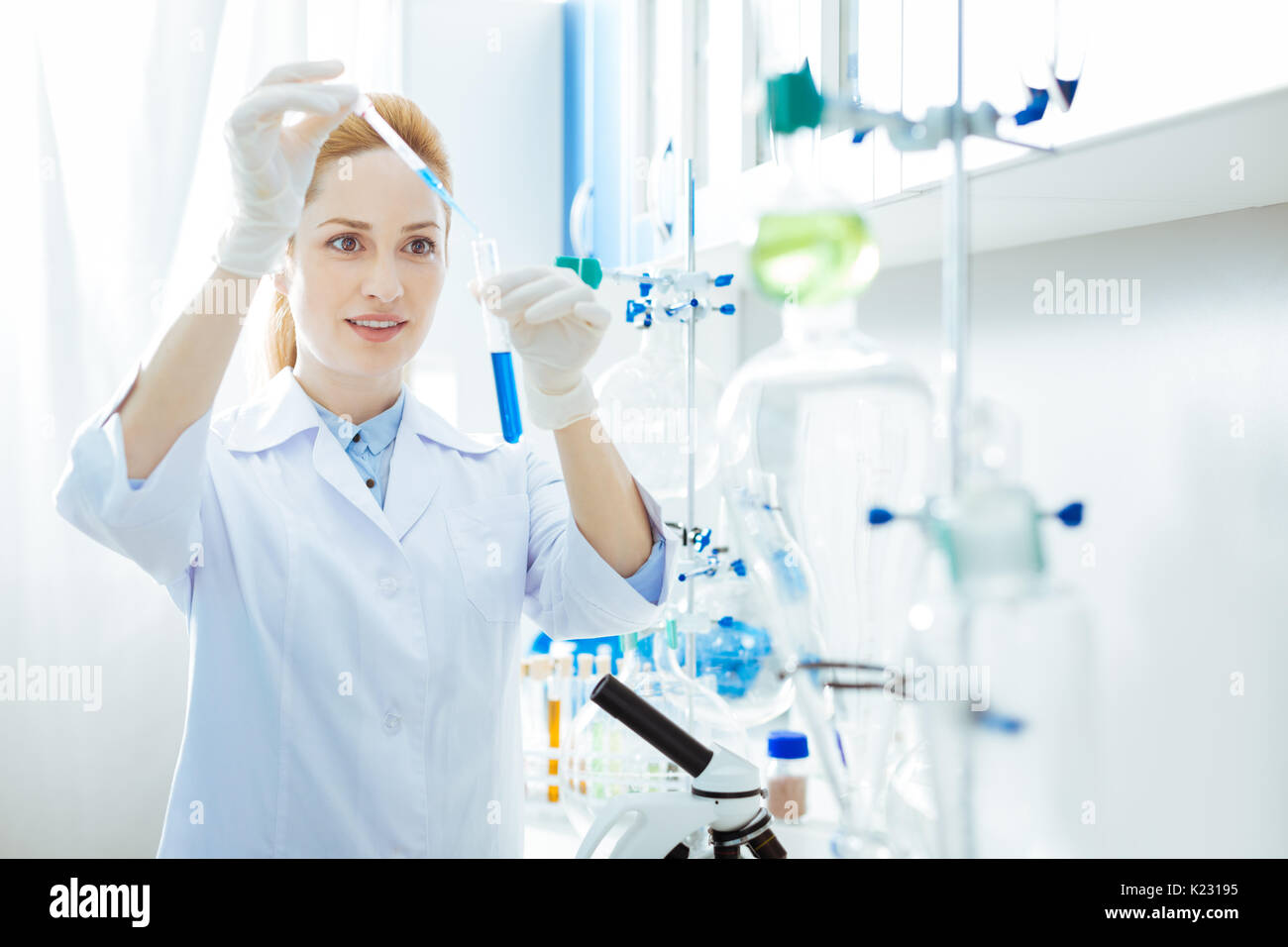 Delighted lab assistant mixing reagents Stock Photo - Alamy