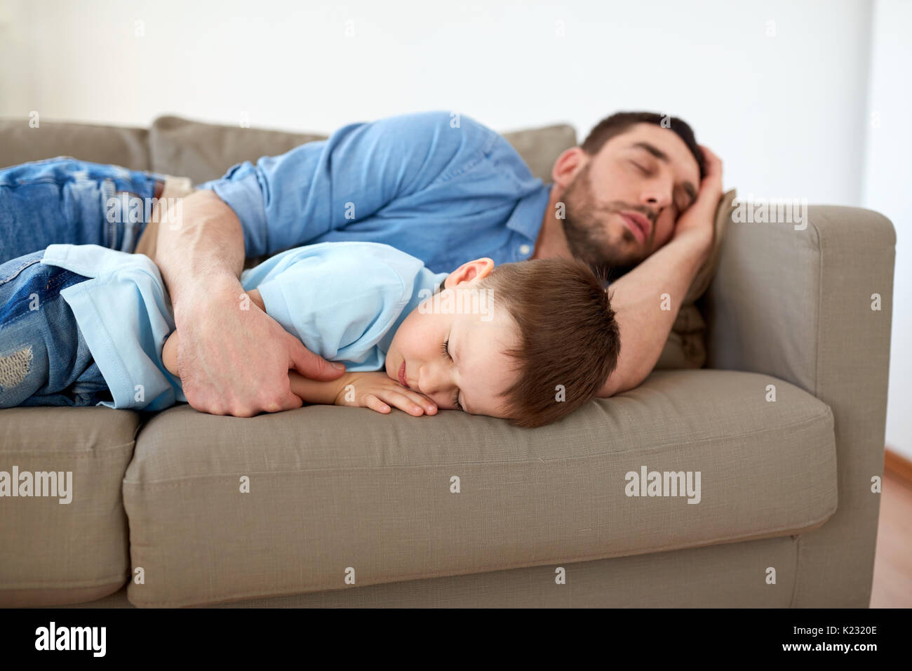happy father and son sleeping on sofa at home Stock Photo - Alamy