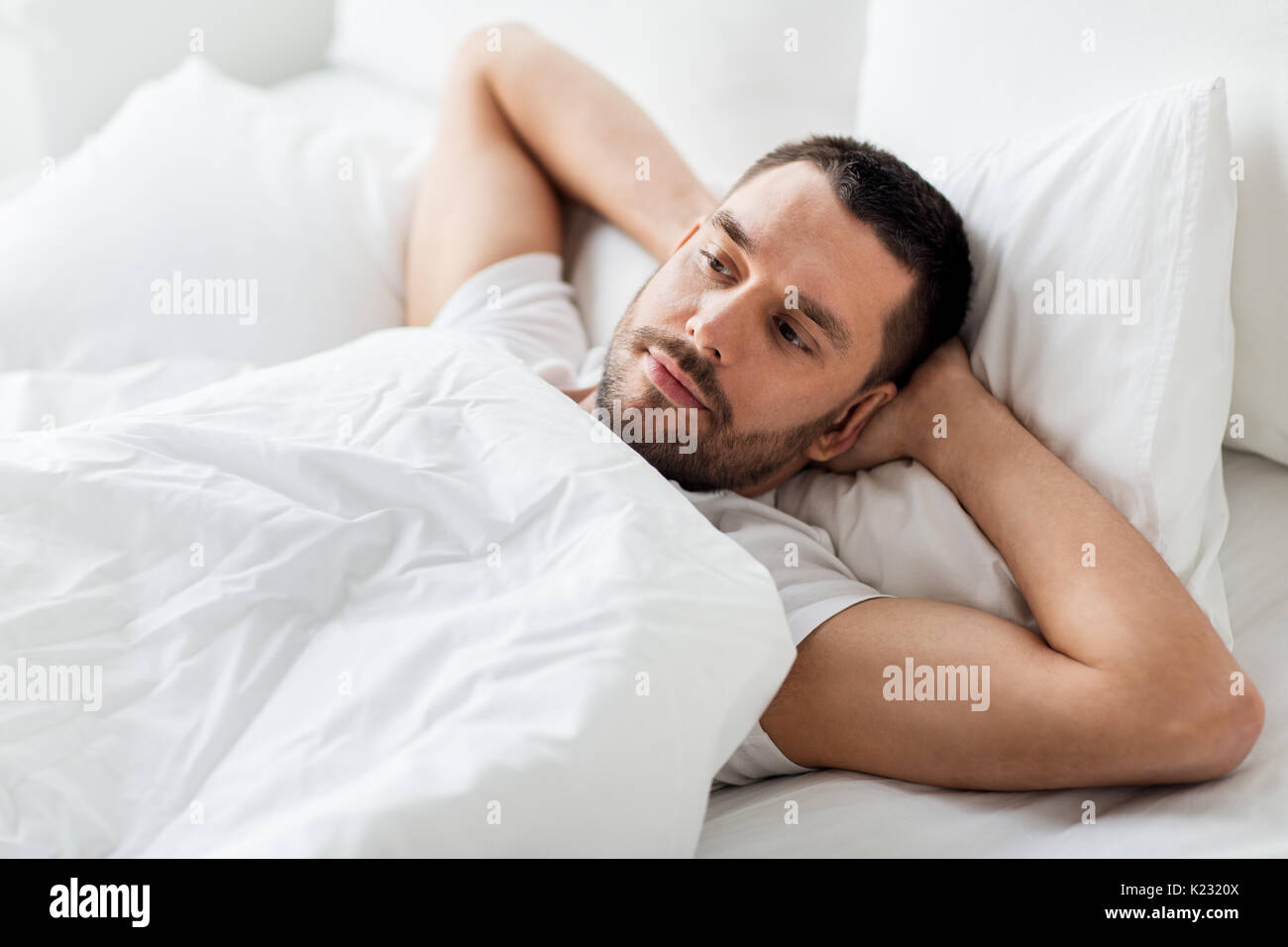 man lying in bed at home Stock Photo - Alamy