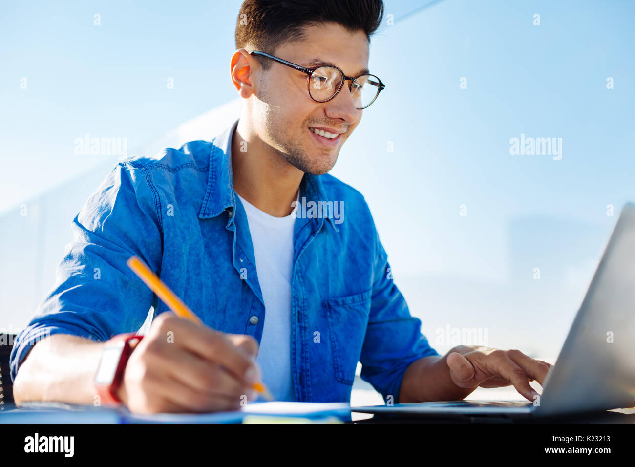Male student enjoying his home assignment outdoors Stock Photo - Alamy