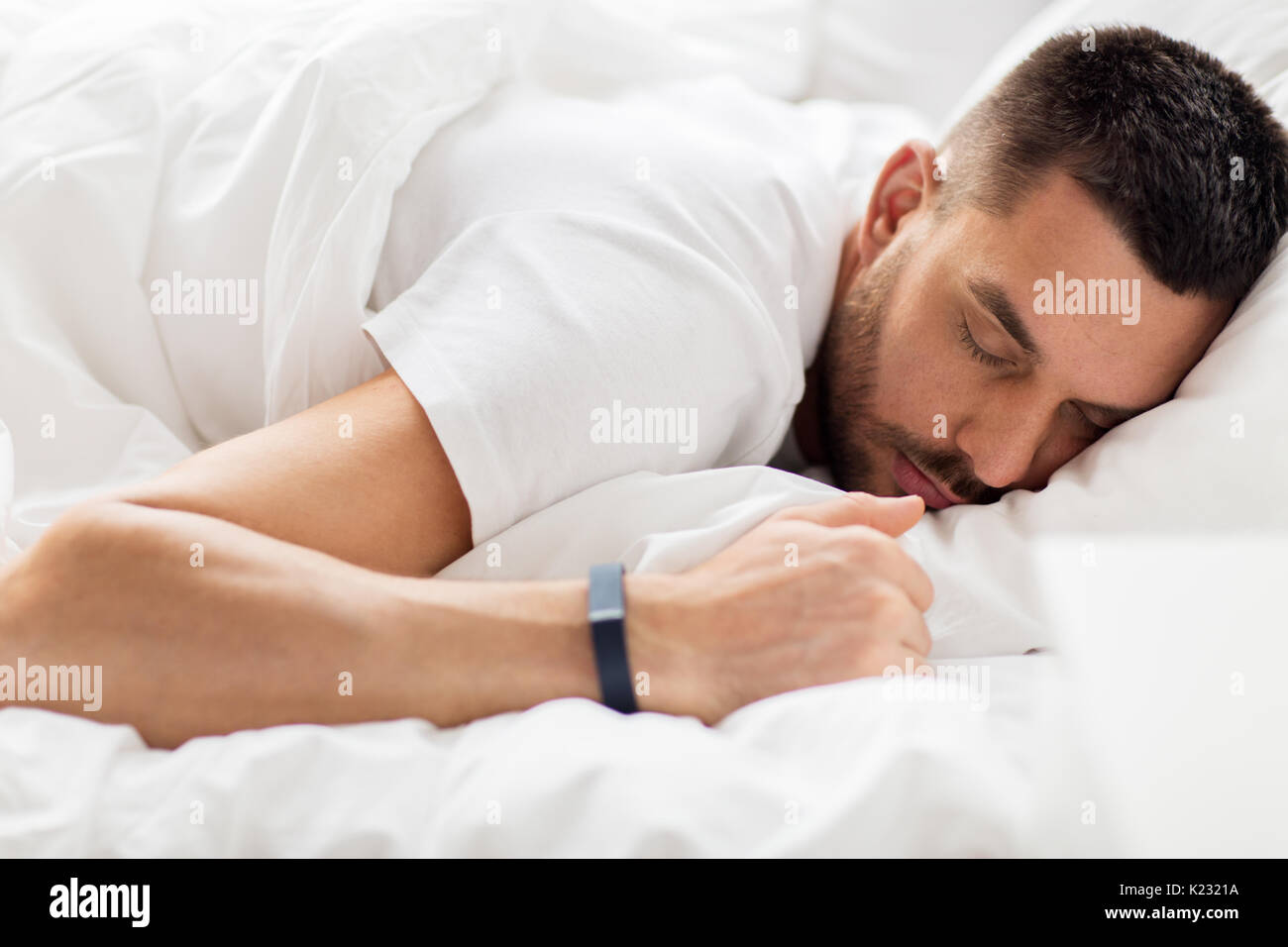 man with smartwatch sleeping in bed Stock Photo - Alamy