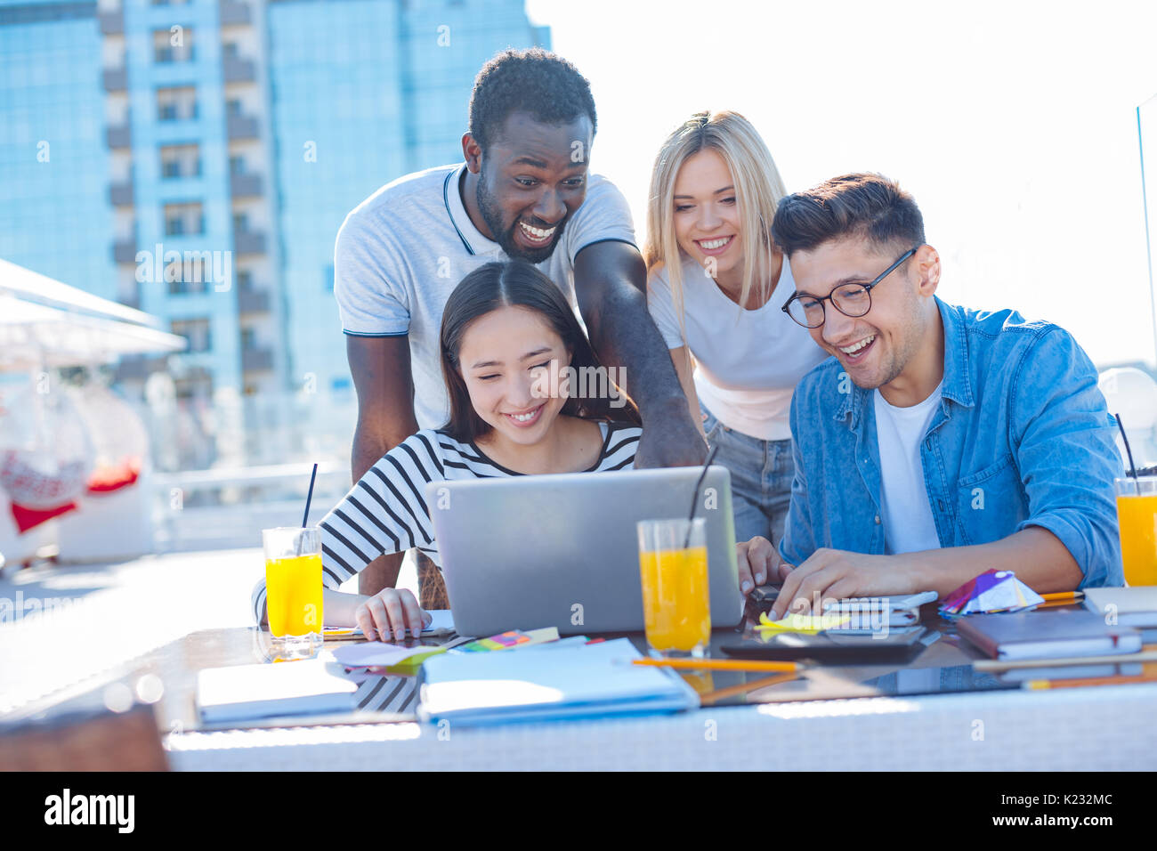 Adorable students smiling while working on project together Stock Photo ...