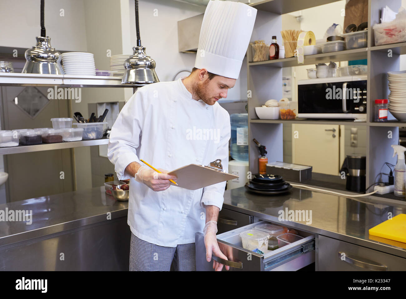 chef with clipboard doing inventory at kitchen Stock Photo - Alamy