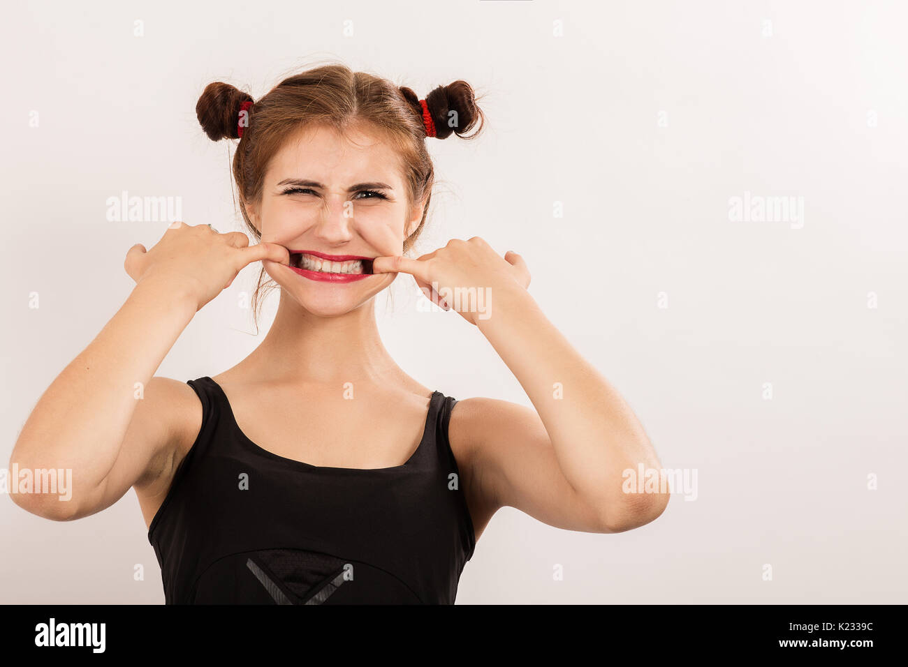 fun beautiful woman grimacing shows her teeth on white background with ...