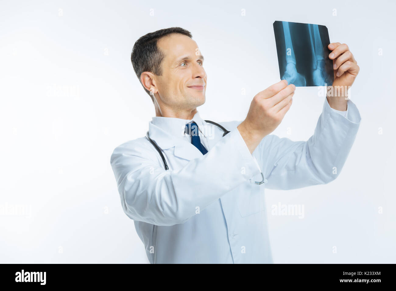 Cheerful doctor smiling while looking at x ray scan Stock Photo - Alamy