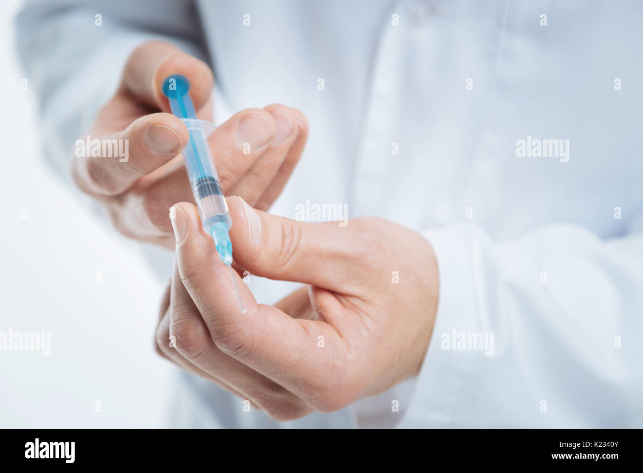 Scale up shot of medical professional checking syringe Stock Photo - Alamy