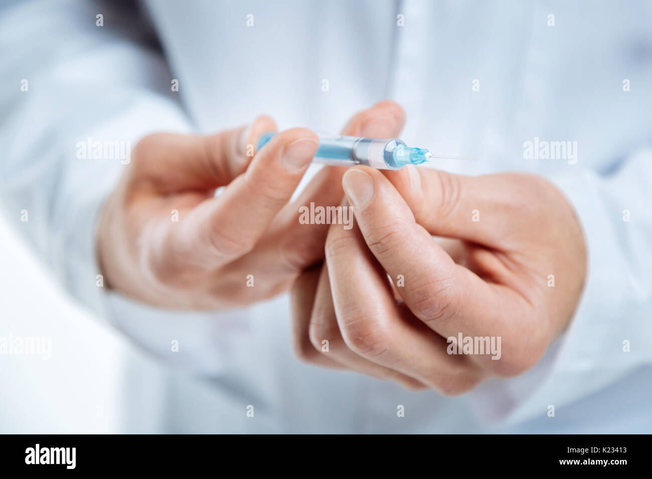 Close up of syringe held by male practitioner Stock Photo - Alamy