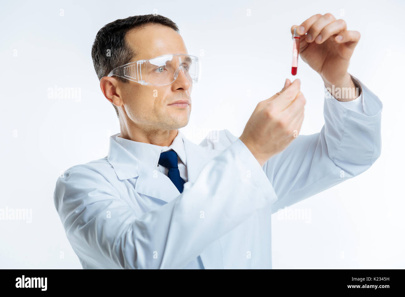 Doctor looking test tube blood hi-res stock photography and images - Alamy