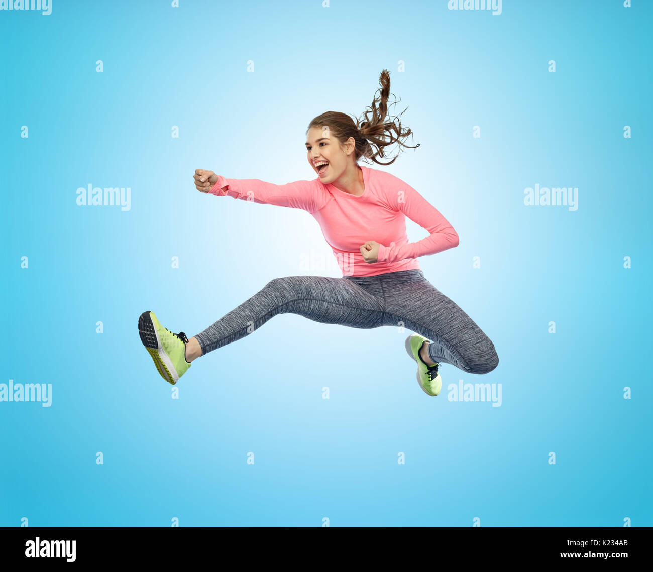 happy sporty young woman jumping in fighting pose Stock Photo - Alamy