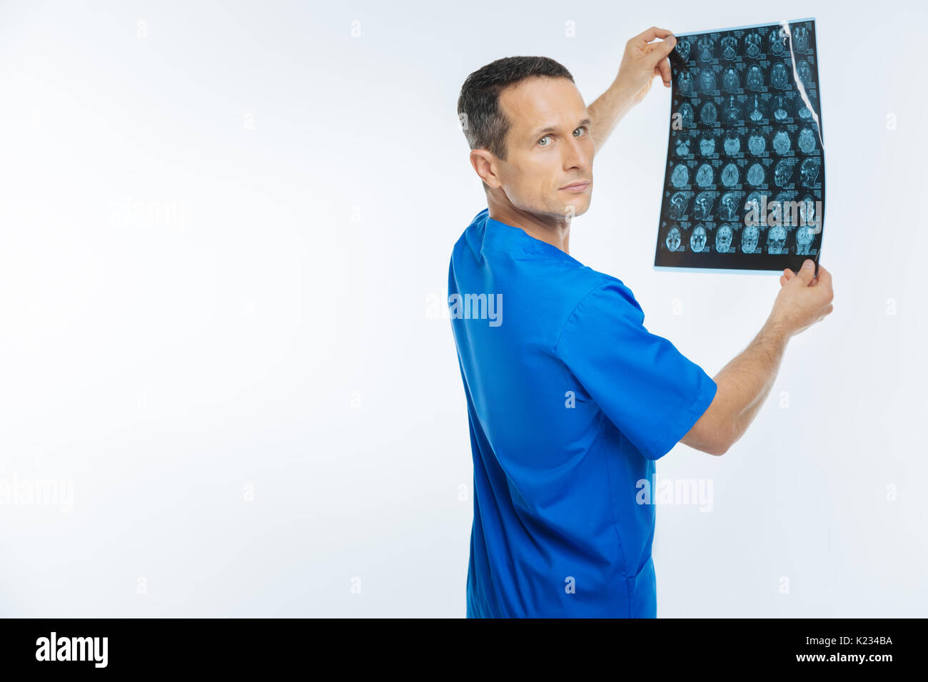 Serious physician with mri scan looking into camera Stock Photo - Alamy
