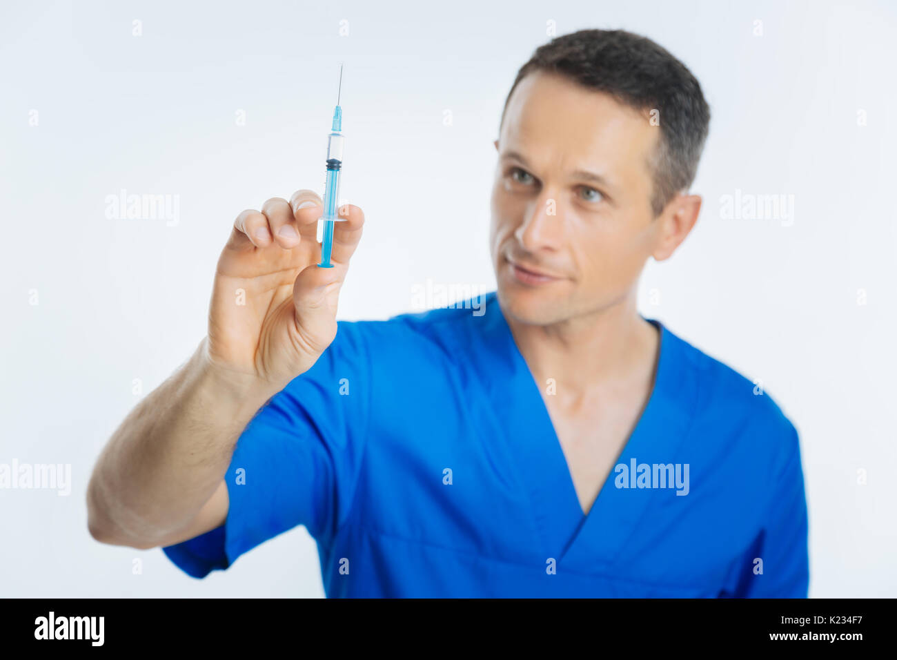 Close up of male practitioner checking syringe Stock Photo - Alamy