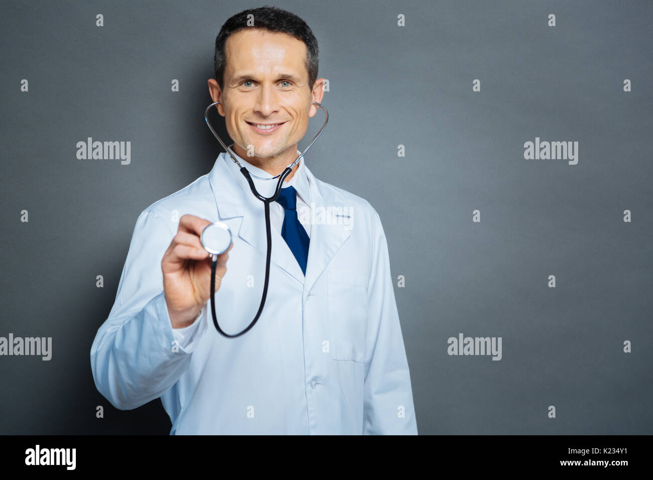 Friendly physician posing with stethoscope Stock Photo - Alamy