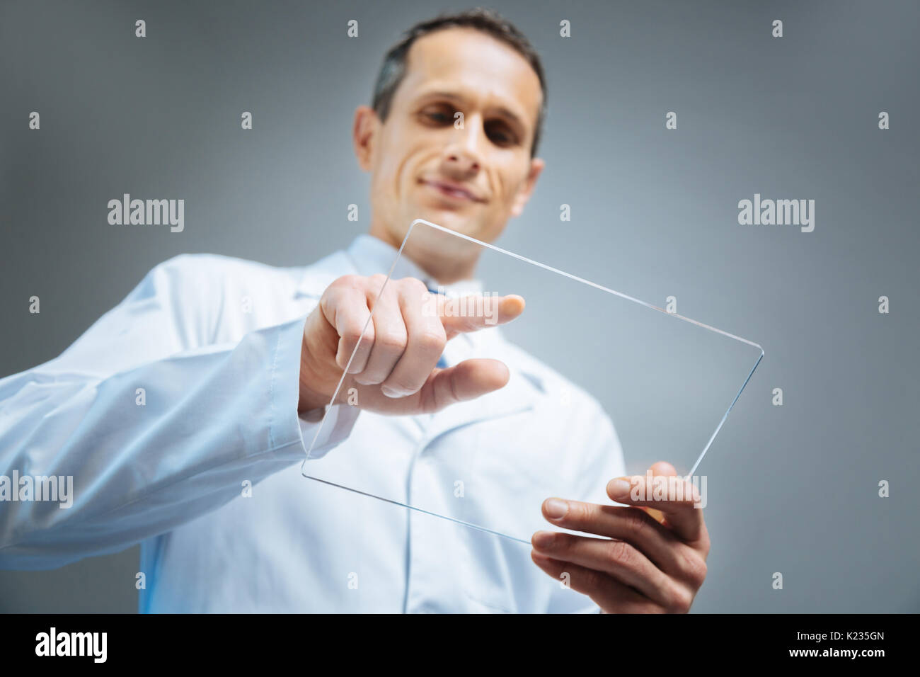 Low angle shot of mature scientist touching invisible device Stock ...