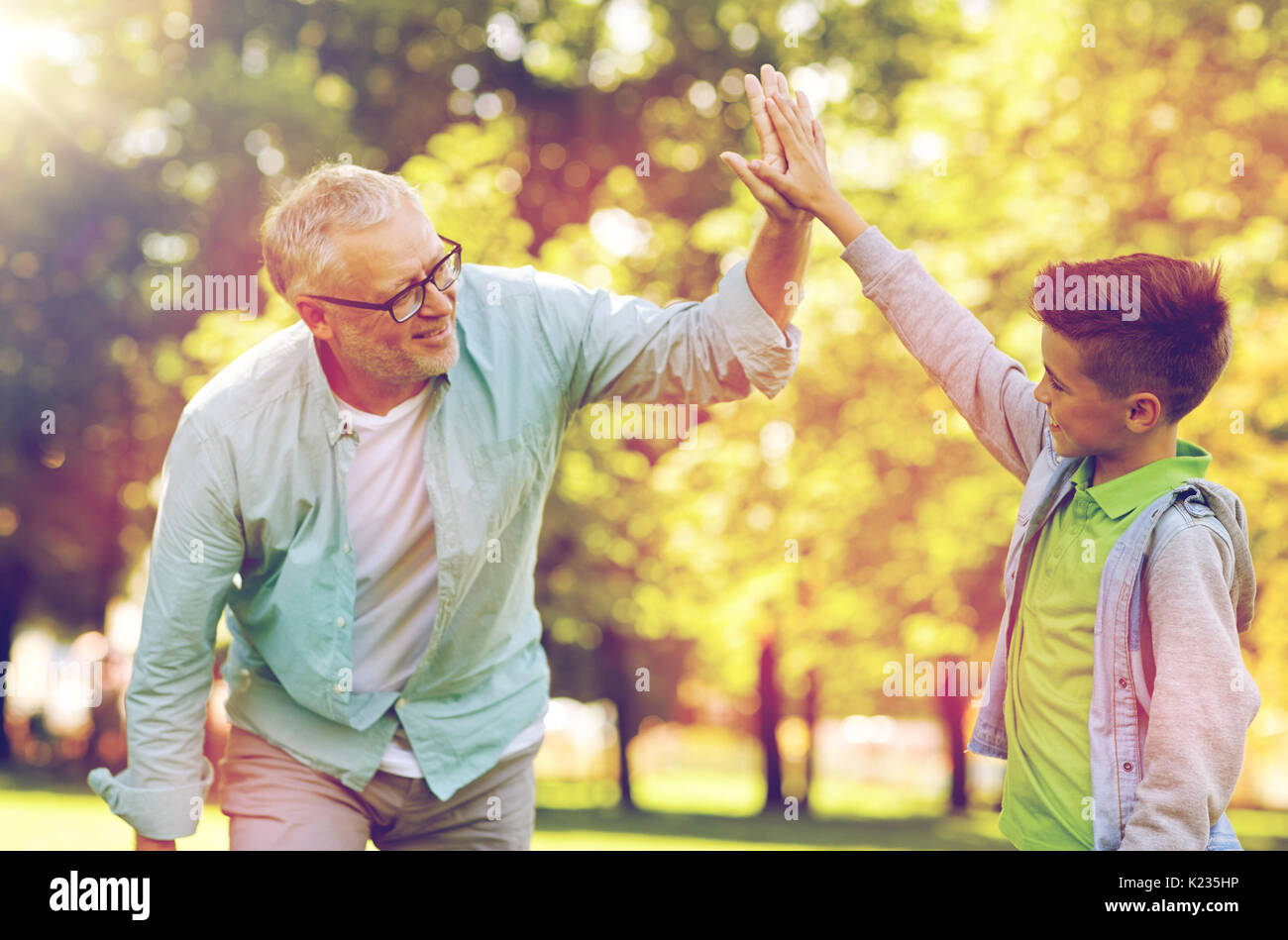 old man and boy making high five at summer park Stock Photo - Alamy