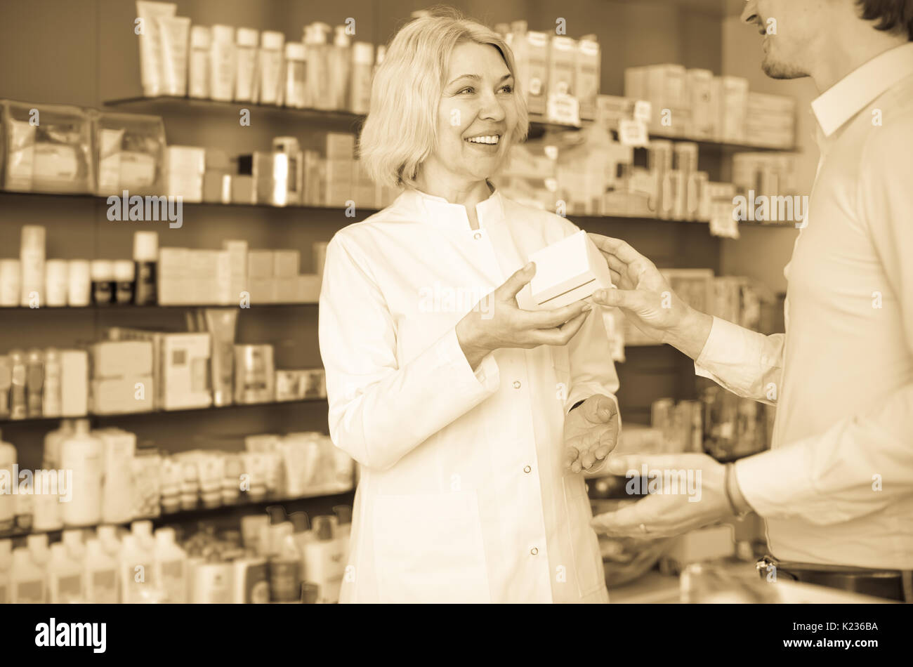 female pharmaceutist staff in drugstore helping customer to choose ...
