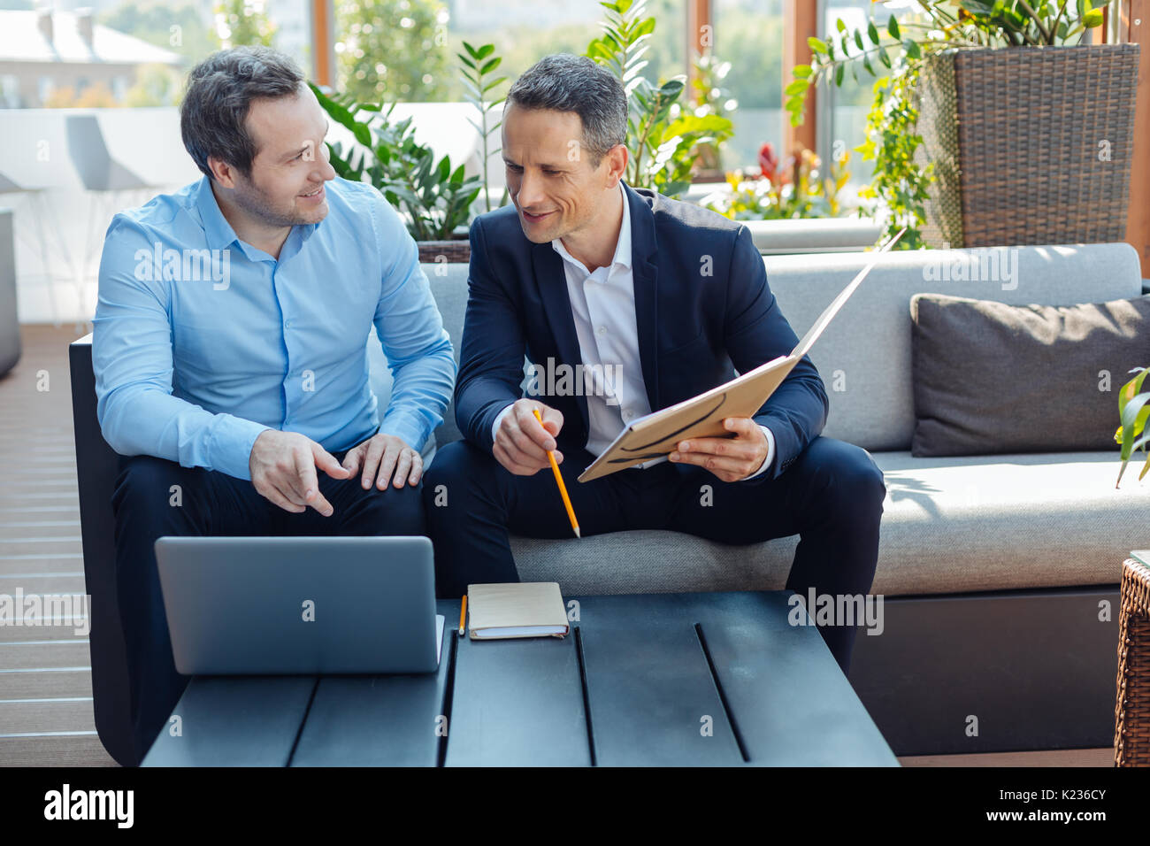 Cheerful smart businessmen discussing their project Stock Photo - Alamy