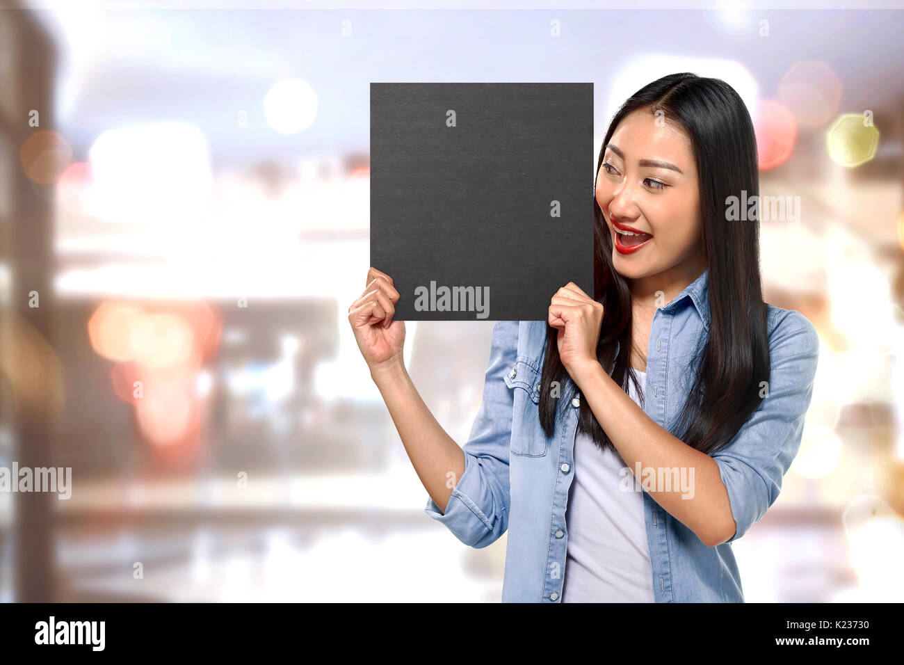 Young asian woman holding sign board with empty space for copyspace ...