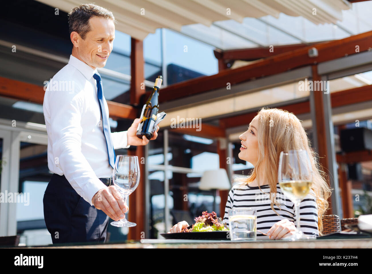 Positive beautiful woman talking to the waiter Stock Photo - Alamy