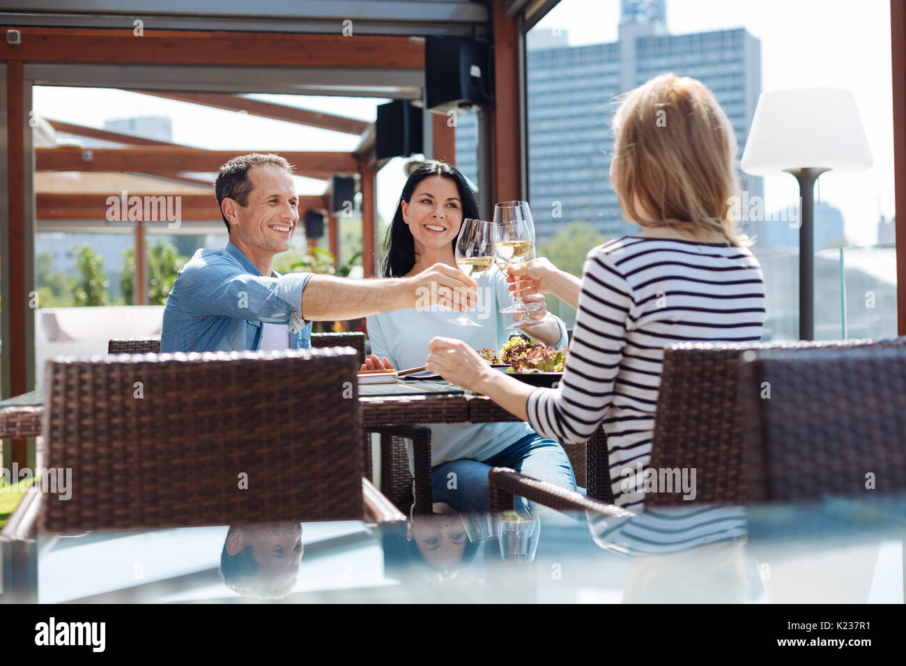 Delighted positive people sitting around the table Stock Photo - Alamy