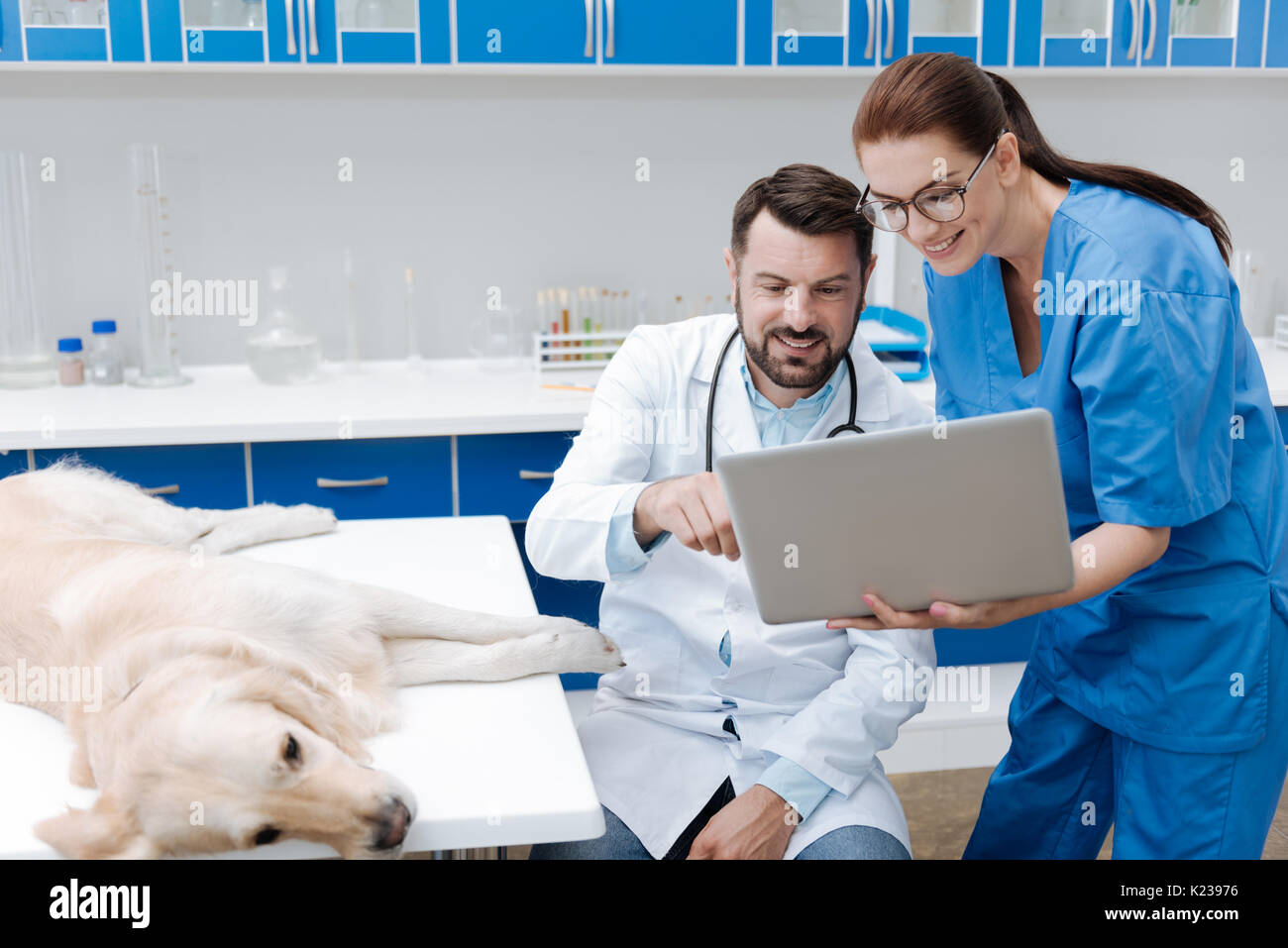 Positive delighted lab assistant holding laptop Stock Photo - Alamy