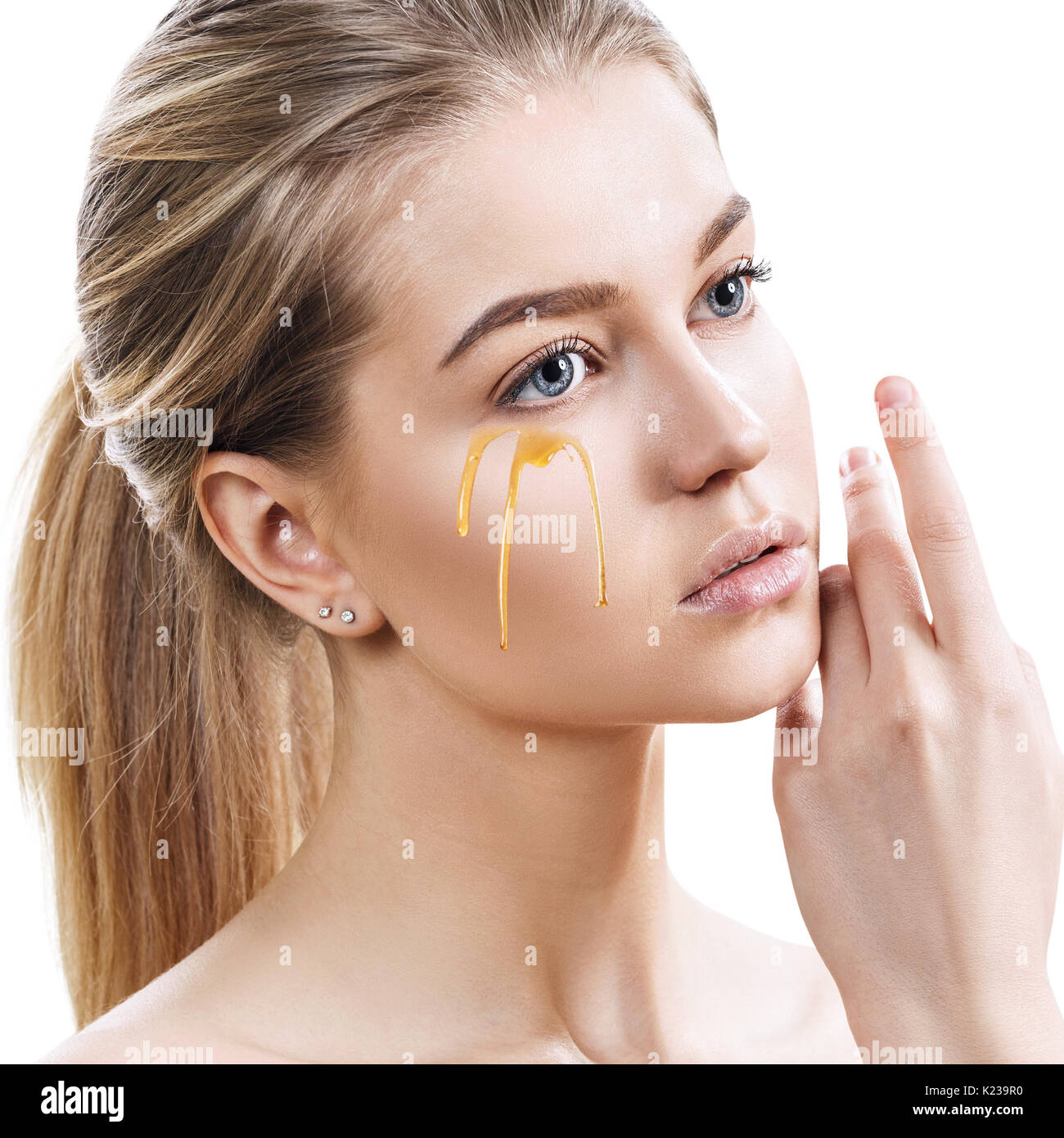 Beautiful woman with honey on face Stock Photo - Alamy