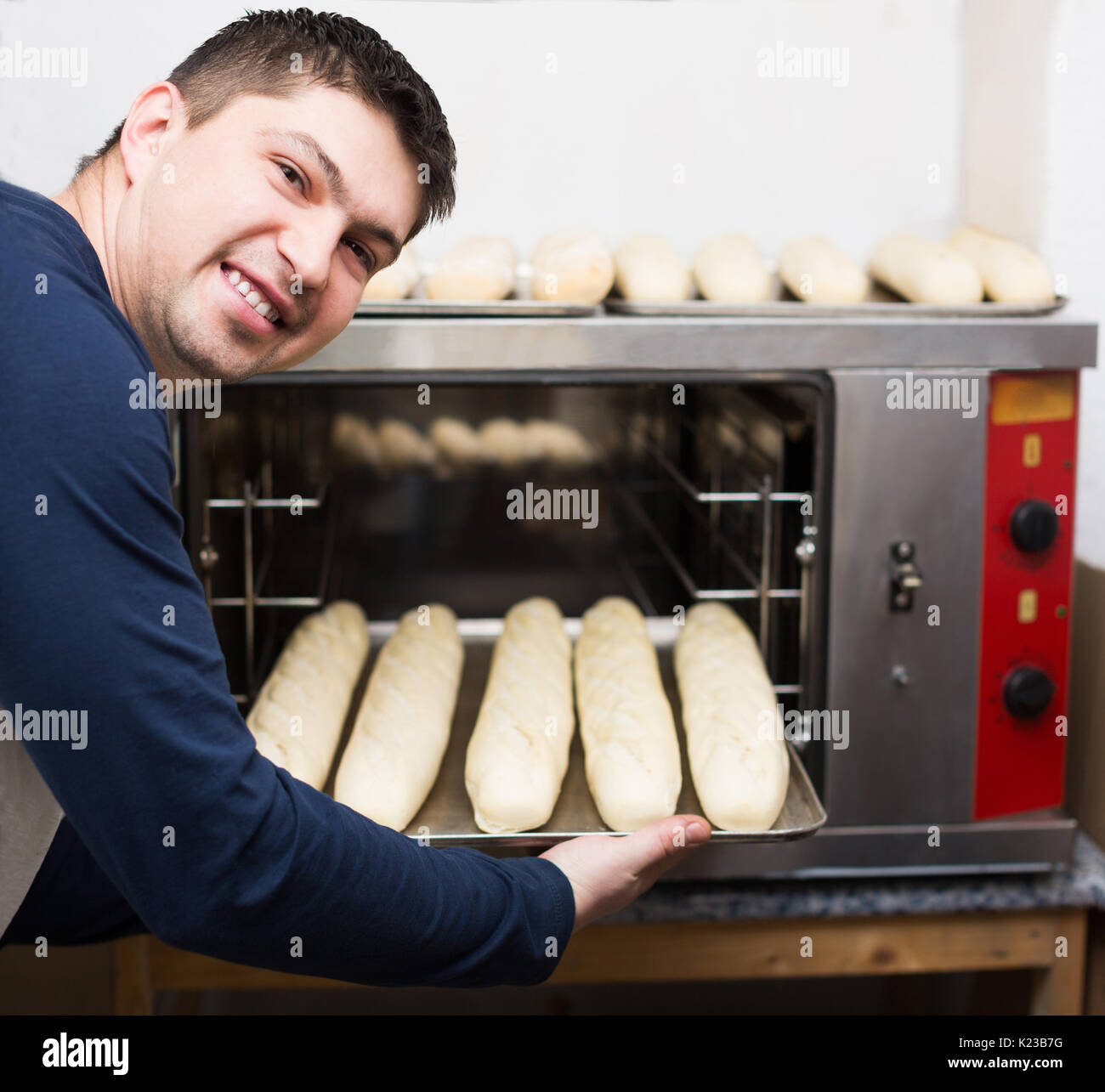 Happy smiling man baking fresh bread at grocery store Stock Photo - Alamy