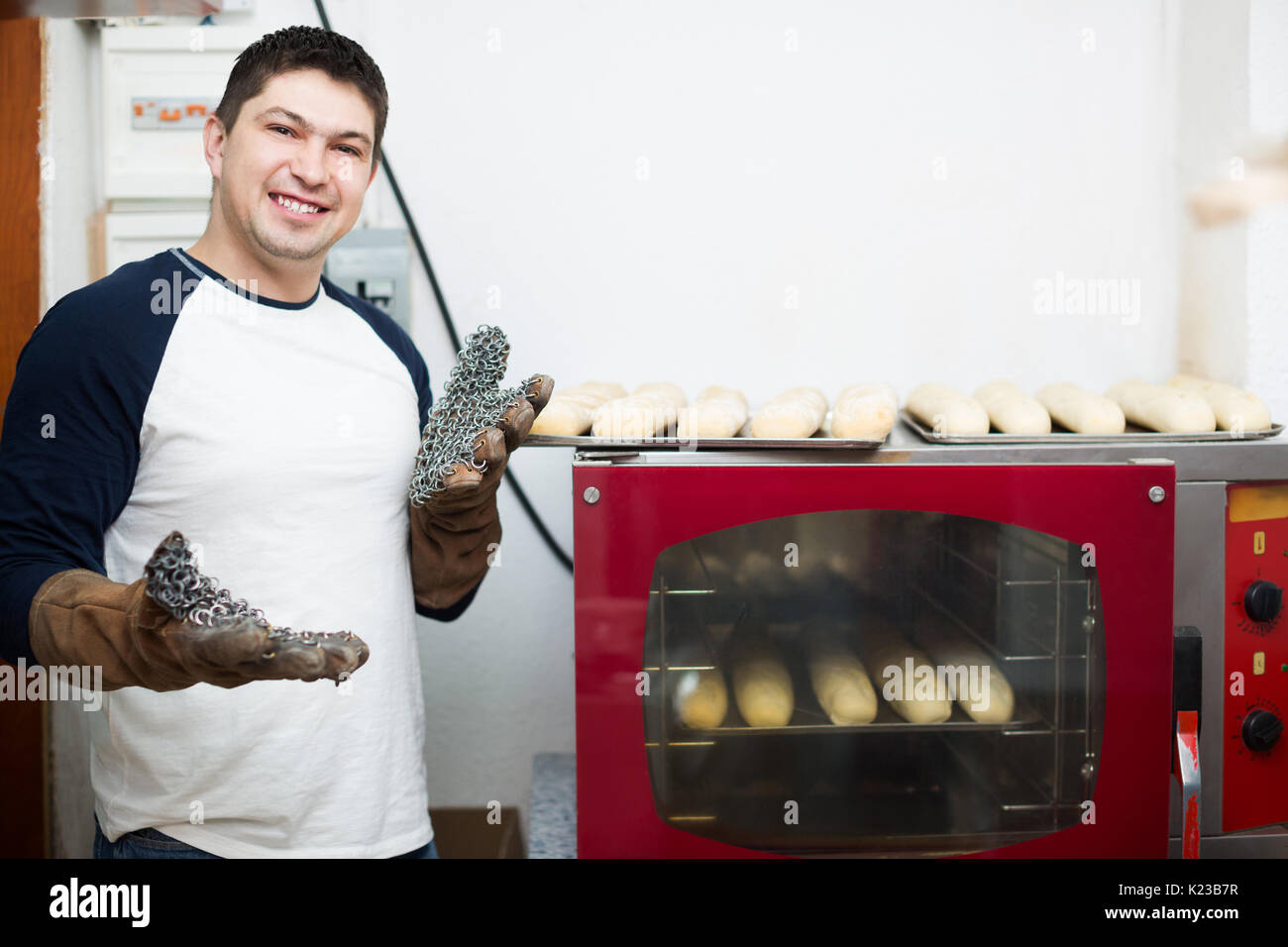 Happy smiling man baking bread at grocery store Stock Photo - Alamy