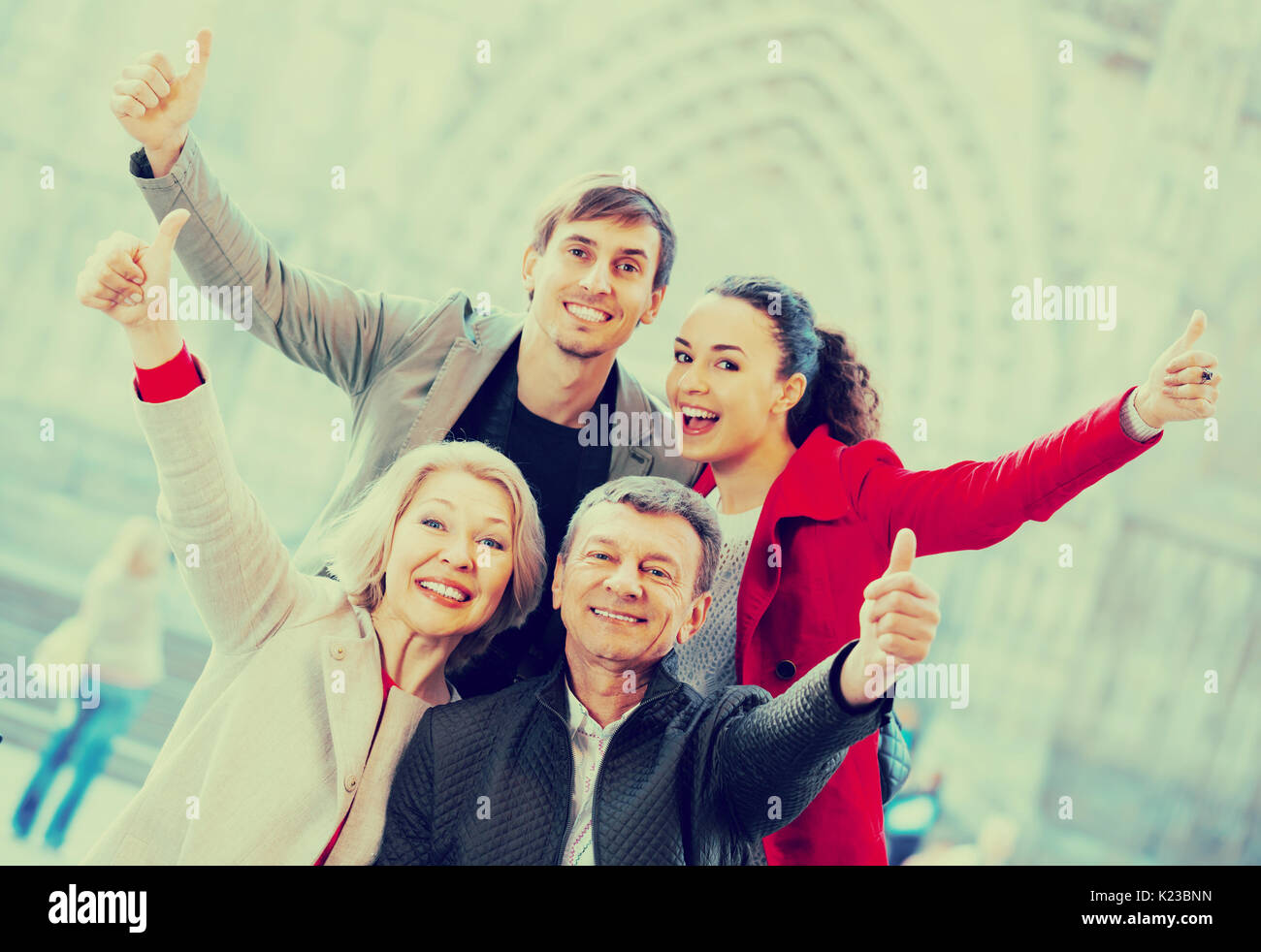 Close up of cheerful smiling tourists posing on European city street ...