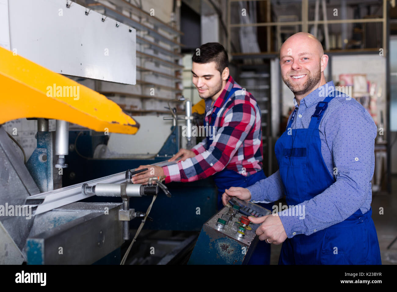 Couple of people near milling machine at factory Stock Photo - Alamy