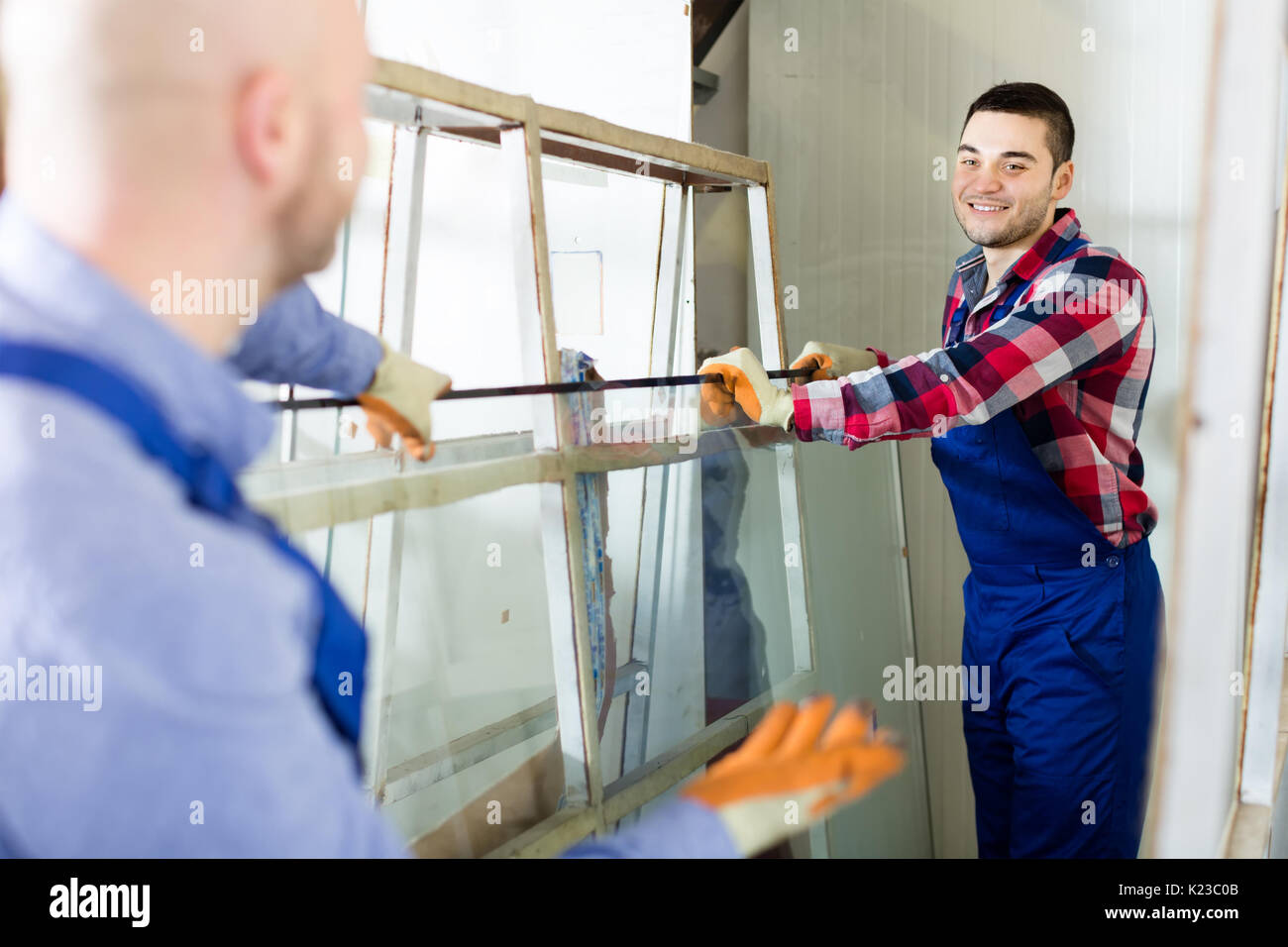Smiling production workers in coverall working with different PVC ...