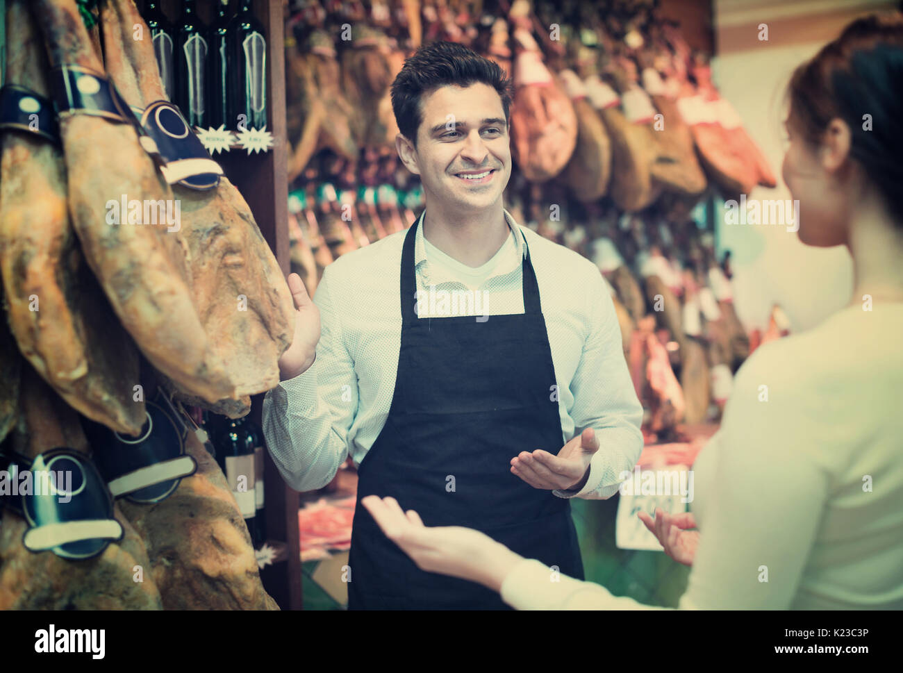 Cute brunette choosing iberico and serrano jamon and smiling Stock ...
